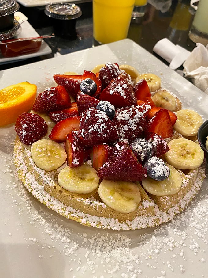 Breakfast or dessert? This fruit-crowned Belgian waffle blurs the line deliciously. The powdered sugar snowfall is just showing off.