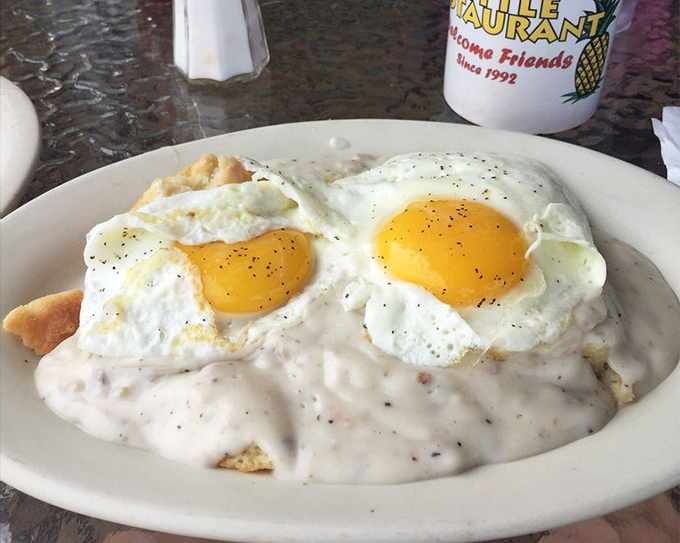 Biscuits and gravy nirvana! Two sunny-side-up eggs crown this creamy masterpiece like royalty overseeing their delicious kingdom.