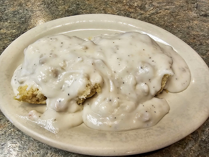 Behold the legendary biscuits and gravy in their natural habitat—a simple white plate that can barely contain all that peppery, creamy goodness.