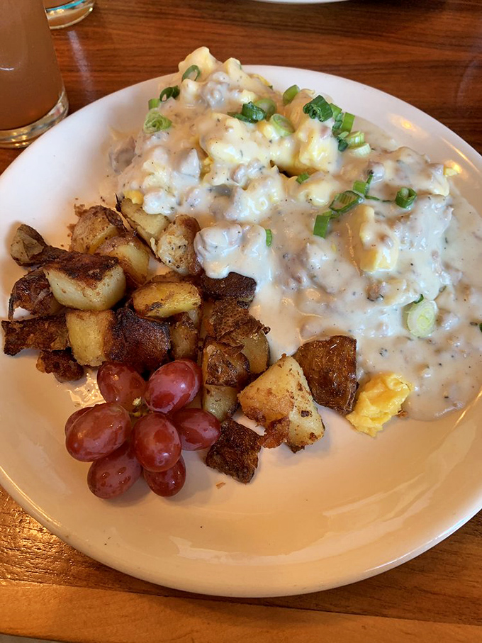 This isn't just biscuits and gravy; it's a cloud of creamy comfort floating above perfectly roasted potatoes with grapes playing innocent bystander.
