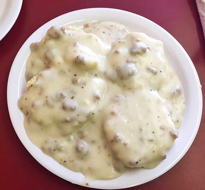 Biscuits and gravy so generous they're practically staging a delicious rebellion against the constraints of the plate.