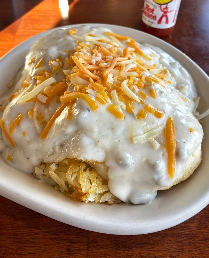 Behold the crown jewel: biscuits and gravy topped with melted cheese that stretches like the truth in a fishing story.
