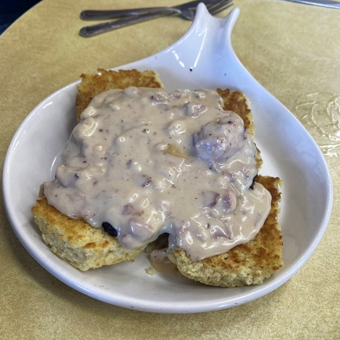 Behold the star attraction: biscuits drowning in peppery sausage gravy that could make even your cardiologist secretly jealous.