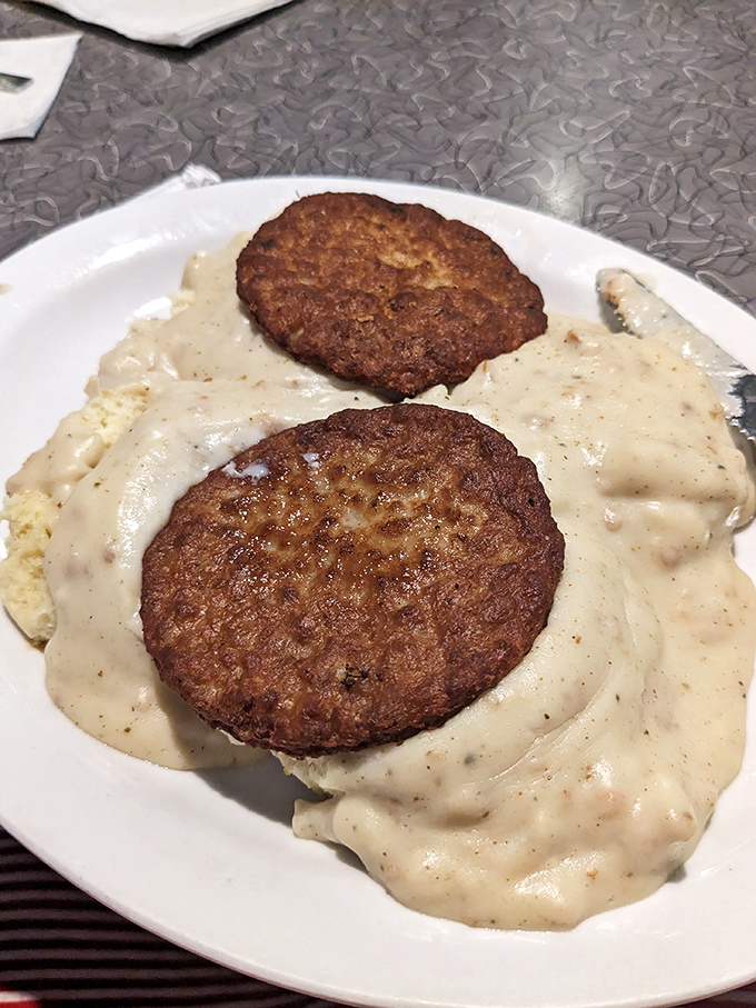 Biscuits and gravy that make you question every other version you've ever had. Those golden-brown discs swimming in peppery heaven deserve their own fan club.