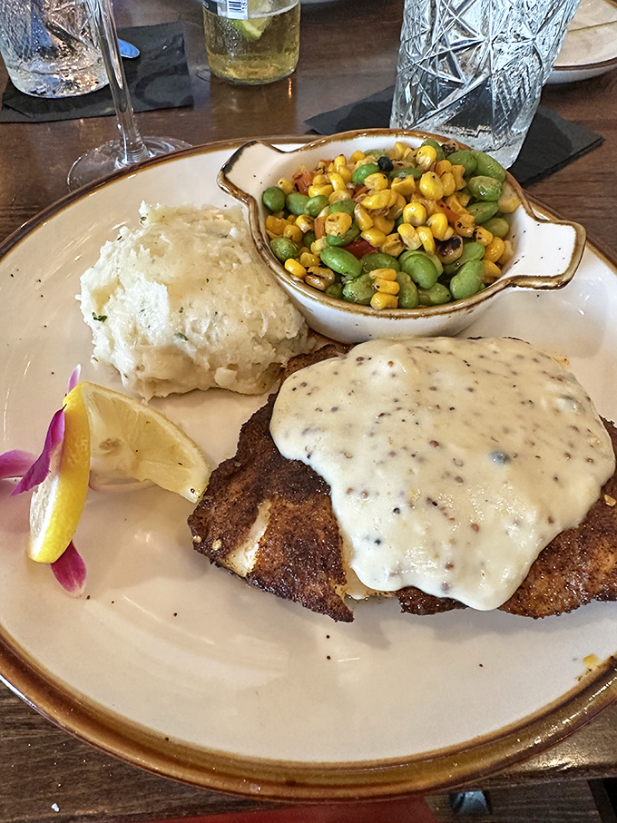The black grouper arrives like a work of art, crowned with a velvety sauce and accompanied by sides that aren't afterthoughts. That corn and edamame medley deserves its own spotlight.