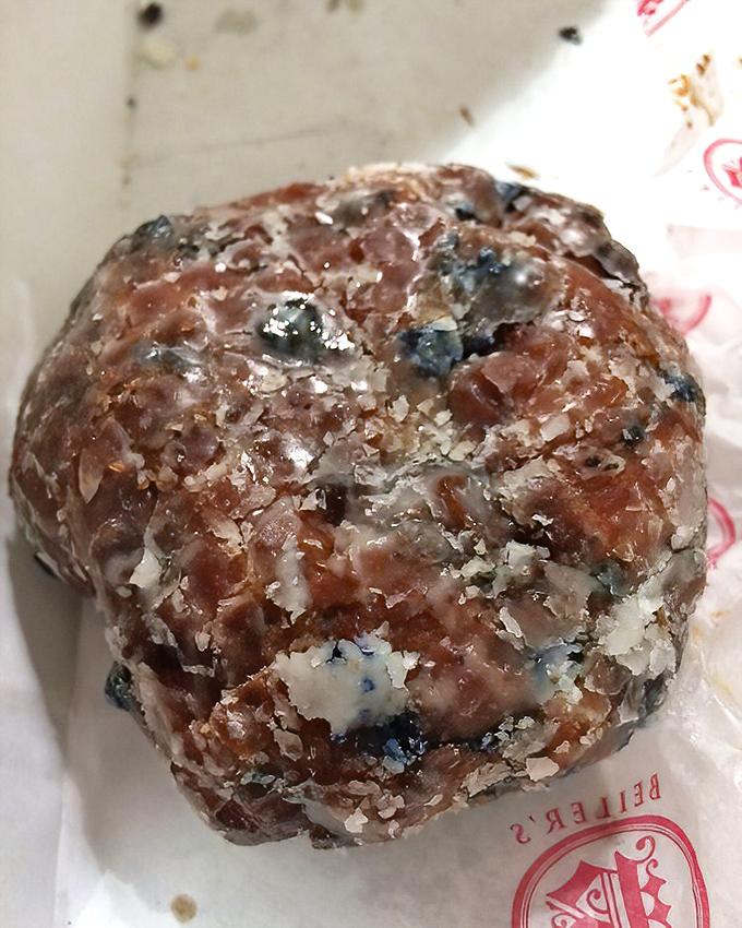 This blueberry fritter isn't just a donut &ndash; it's a commitment. Glistening with glaze and studded with berries, it's breakfast disguised as dessert.