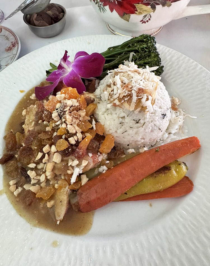 The Bombay Chicken Curry arrives like a colorful ambassador from another world, complete with diplomatic immunity from calorie counting.