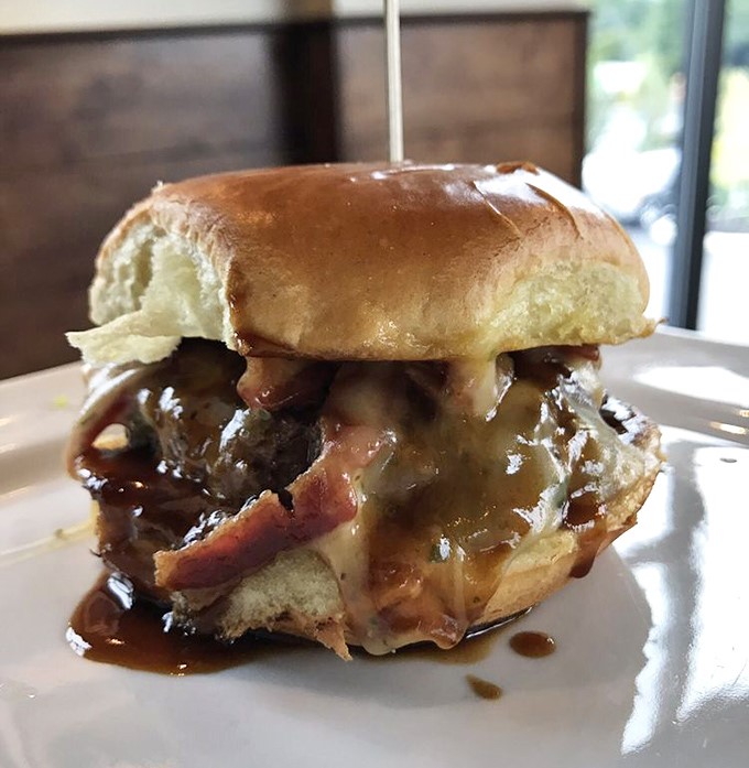 This bourbon burger isn't just a meal, it's an event. The sauce cascades down like a delicious waterfall, demanding both napkins and respect.