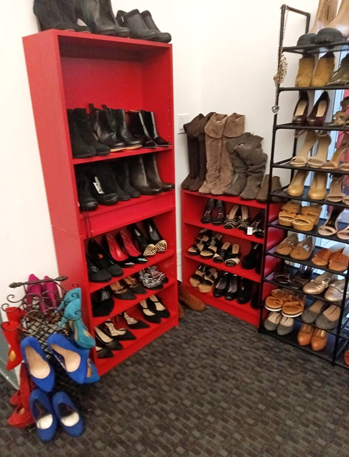 The shoe section is organized with a precision that would make Marie Kondo weep with joy. Red shelving creates the perfect backdrop for footwear finding its second act.
