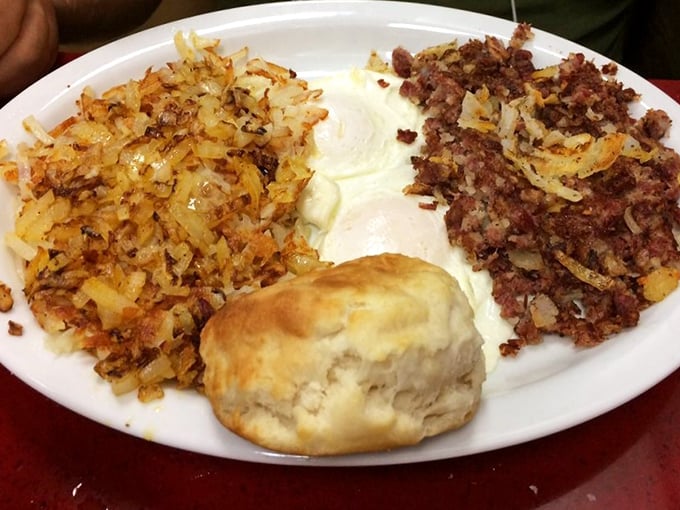 Breakfast nirvana: crispy hash browns, perfectly seasoned corned beef hash, eggs just right, and a biscuit that would make your grandmother both proud and jealous.