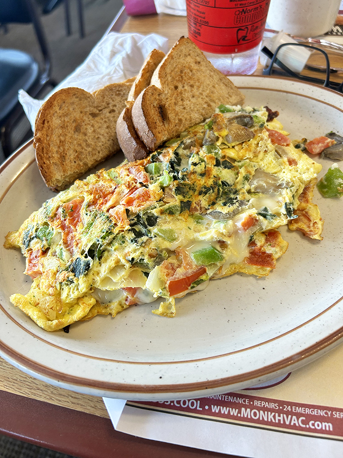 Behold the veggie omelet masterpiece - fluffy eggs embracing garden treasures like a warm, delicious hug.