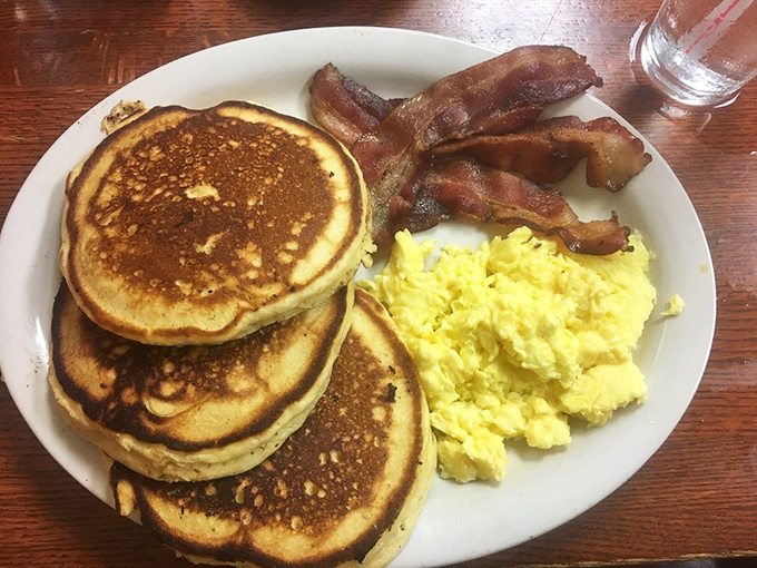 Stack 'em high, serve 'em proud! These golden pancakes with perfectly scrambled eggs and crispy bacon form the holy trinity of breakfast satisfaction.