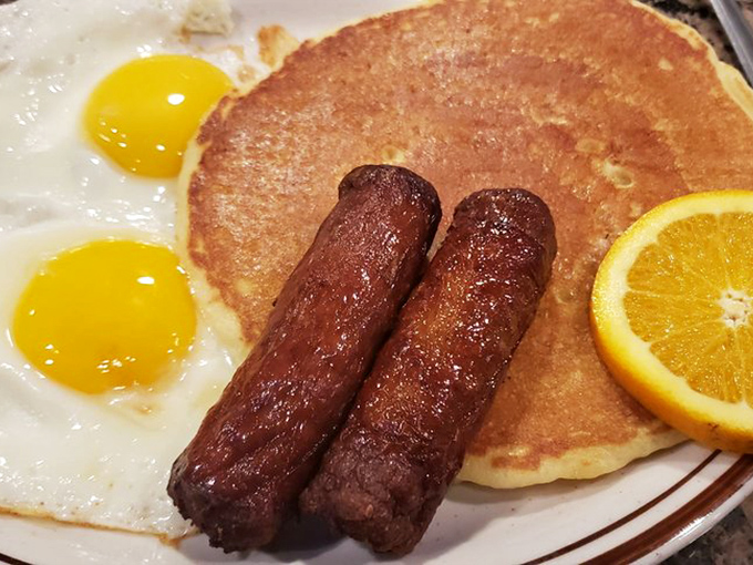 Breakfast perfection doesn't need fancy plating. Two sunny-side-up eggs, sausage links, and a pancake that could make IHOP weep with jealousy.