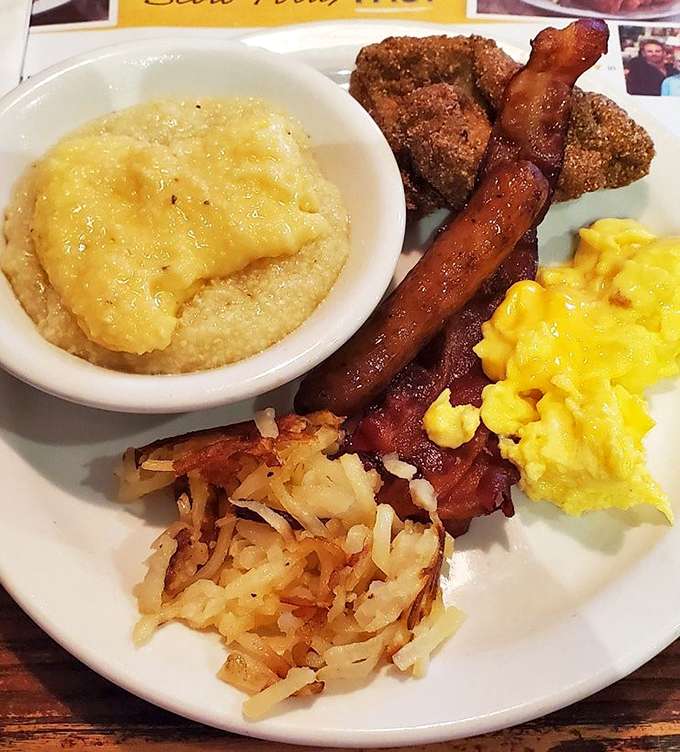 Breakfast nirvana on a single plate: creamy grits, crispy hash browns, perfectly scrambled eggs, and bacon that makes you question all other bacon you've ever eaten.