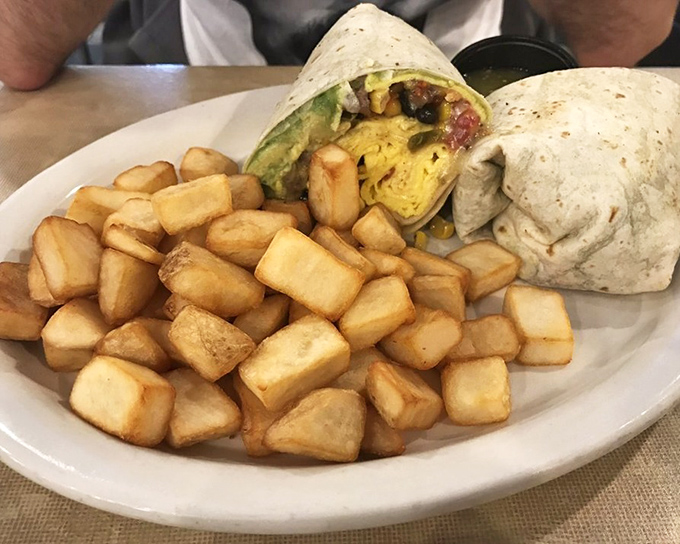 Behold the breakfast burrito in its natural habitat &ndash; a tortilla-wrapped miracle flanked by home fries that could make a potato farmer weep with pride. 