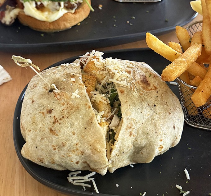 This isn't just any wrap—it's a handheld flavor fiesta, stuffed to bursting and paired with golden fries that demand to be savored one crispy bite at a time.