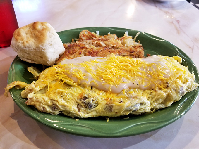 This isn't just an omelet; it's a cheese-blanketed masterpiece with hash browns so perfectly crispy they deserve their own fan club.