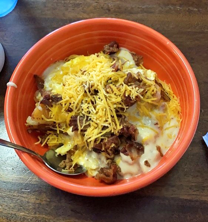 Breakfast alchemy at its finest&mdash;potatoes, eggs, meat, and cheese coming together in a vibrant orange bowl to create the ultimate morning fuel.