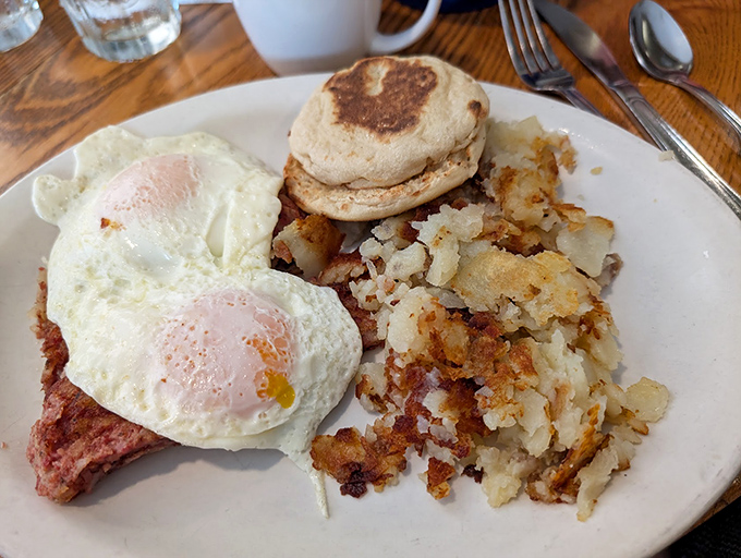 Breakfast perfection on a plate&mdash;sunny-side up eggs lounging atop ham steak with crispy hash browns and an English muffin standing by for yolk duty.