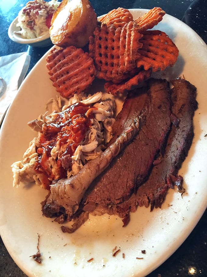 Behold the holy trinity of barbecue perfection: brisket with that coveted smoke ring, pulled pork with sauce, and those waffle fries that haunt your dreams.
