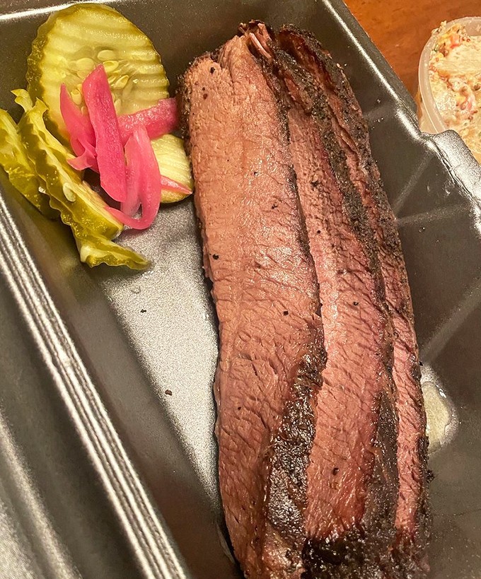Behold the brisket&mdash;pink smoke ring, peppery bark, and that telltale tenderness that speaks of hours in the smoker. Pickles provide the perfect acidic counterpoint.