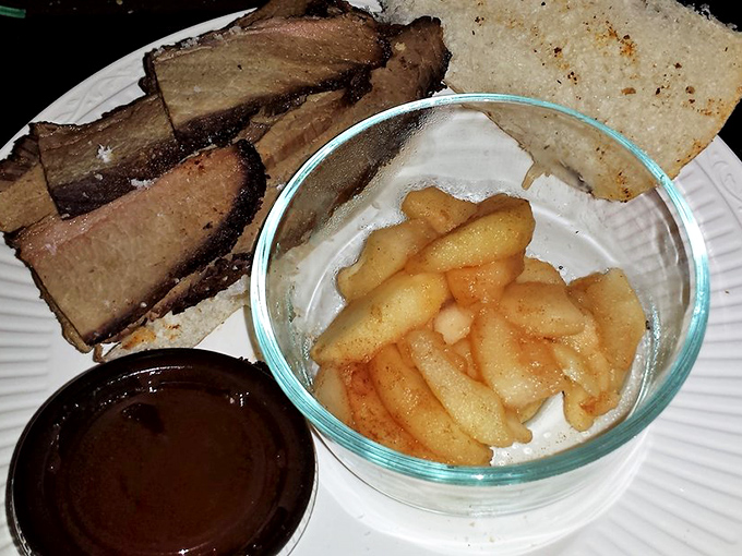 Brisket that doesn't need a fancy plate to impress. These smoke-kissed slices, paired with homemade applesauce and cornbread, prove that true love comes in styrofoam containers.