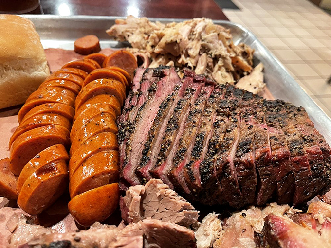 Behold the holy trinity of BBQ perfection: sliced brisket with that coveted smoke ring, juicy sausage, and pulled meat that practically winks at you. 
