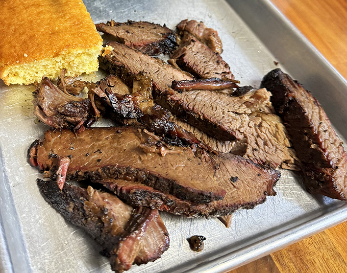 Brisket so tender it practically surrenders at the sight of your fork, with that telltale pink smoke ring that makes BBQ enthusiasts weak in the knees.