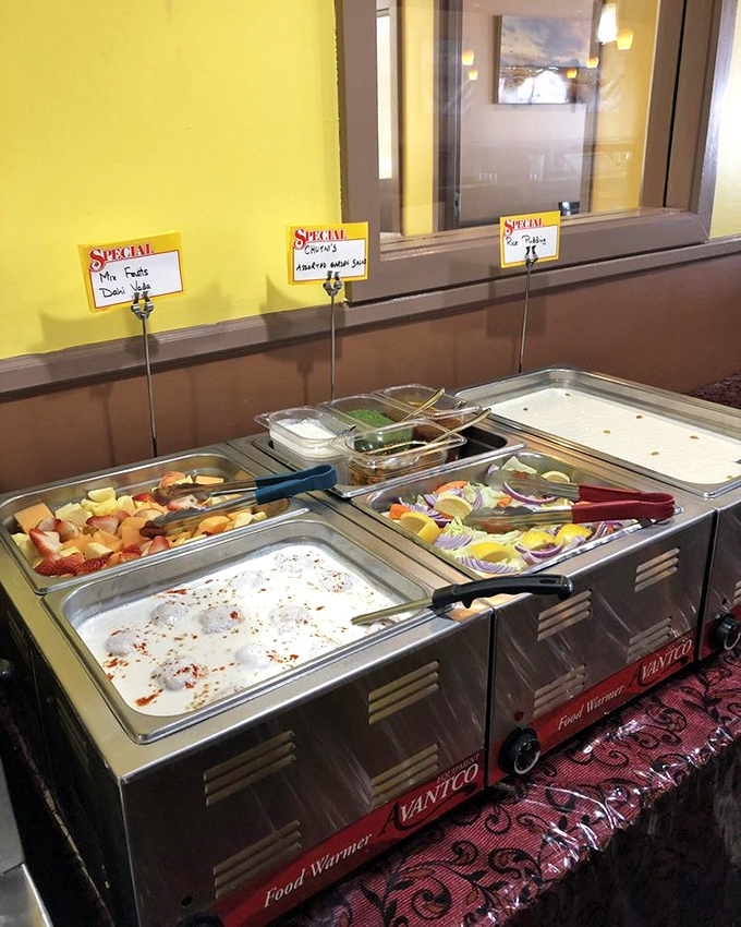 Buffet stations gleaming with promise—where raita meets fruit chaat and every ladle dip brings you closer to culinary nirvana.