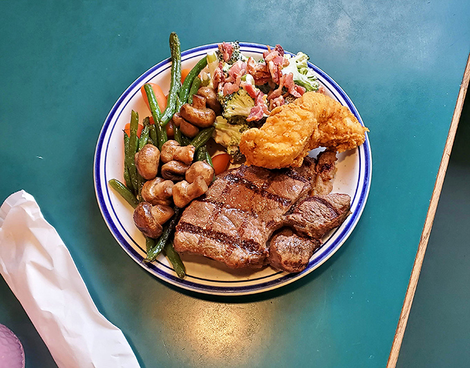 A plate that tells the whole story: perfectly grilled steak, golden fried chicken, and vegetables that didn't come from a freezer. Buffet nirvana achieved.