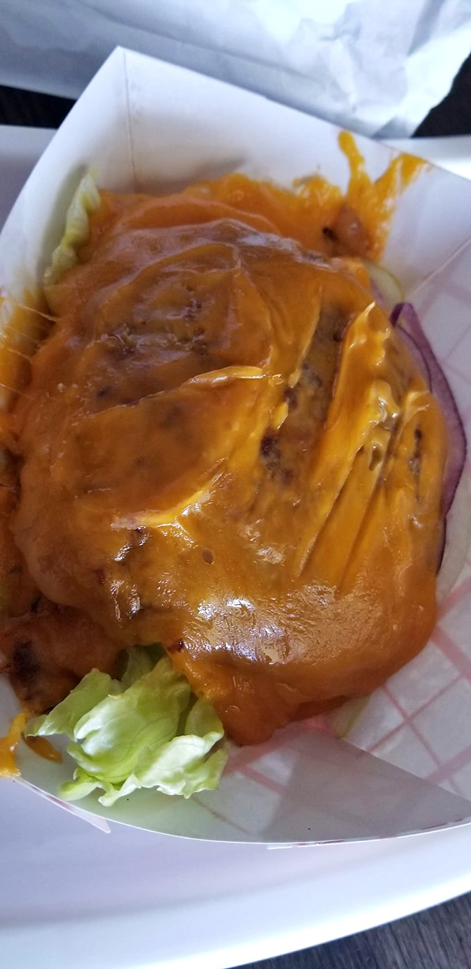 Cheese lovers, rejoice! This mountain of melted cheddar doesn't just cover the burger—it creates a crispy, savory halo that's worth the drive.