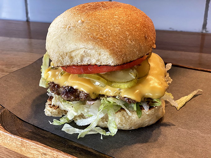 Behold, the classic American dream in edible form. This perfectly constructed burger demonstrates architectural integrity that would make Frank Lloyd Wright weep into his ketchup.