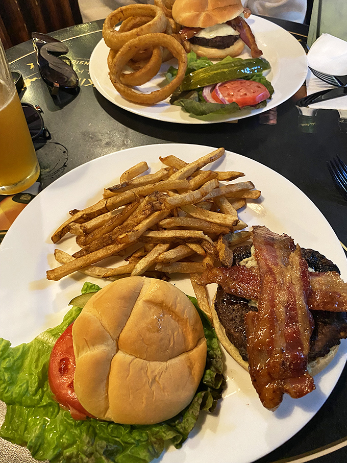Behold the burger in all its glory! Perfectly charred patty, melted cheese, and those onion rings looking like golden halos of deliciousness.