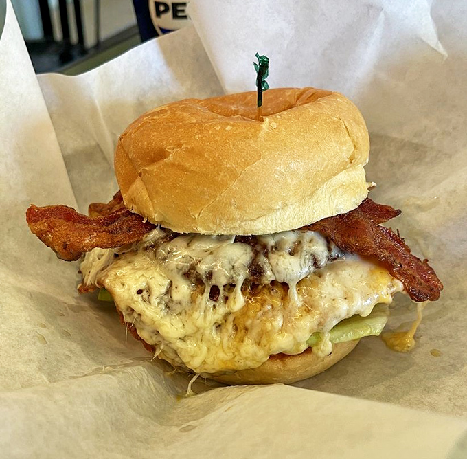 Behold the burger that launched a thousand road trips. That melty cheese cascade and perfectly positioned bacon strips are what food dreams are made of.
