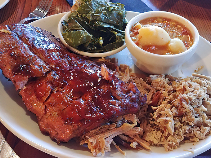 Glistening ribs share the plate with collards and Brunswick stew—a holy trinity of Southern comfort. This isn't just dinner; it's edible heritage.