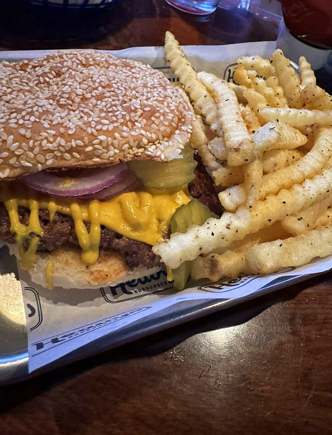 Behold the star of the show: sesame-studded bun, melty cheese cascading over the patty, and those perfect crinkle-cut fries standing guard.