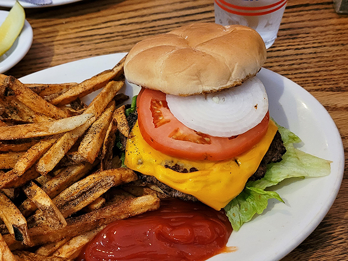 This isn't just a cheeseburger&mdash;it's architecture. The foundation is beef, the infrastructure is cheese, and those fries are the landscaping. 