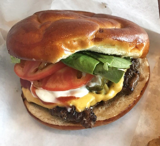 This isn't just a cheeseburger—it's a masterpiece of melty cheese, garden-fresh toppings, and a perfectly seasoned patty on a brioche bun that refuses to surrender.