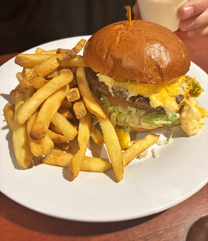 This isn't just a cheeseburger&mdash;it's architecture. The golden ratio of beef to cheese to bun, with fries standing guard like delicious sentinels.