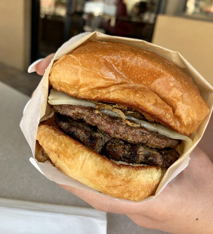 Behold the burger in its natural habitat &ndash; perfectly charred, gloriously juicy, and nestled in a toasted bun. Poetry between bread.