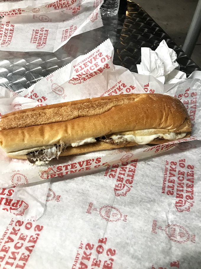 Behold the white-wrapped wonder—ribbons of thinly sliced beef embraced by melted cheese in a perfect roll. Poetry you can eat.