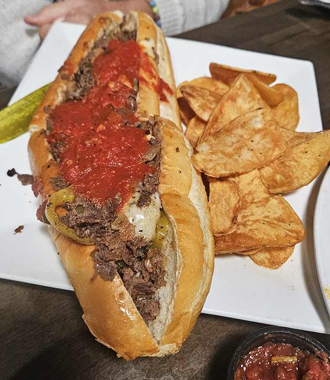 Behold, the star of the show! This marinara-topped cheesesteak isn't just a sandwich&mdash;it's a Pennsylvania passion project served with perfectly golden chips.