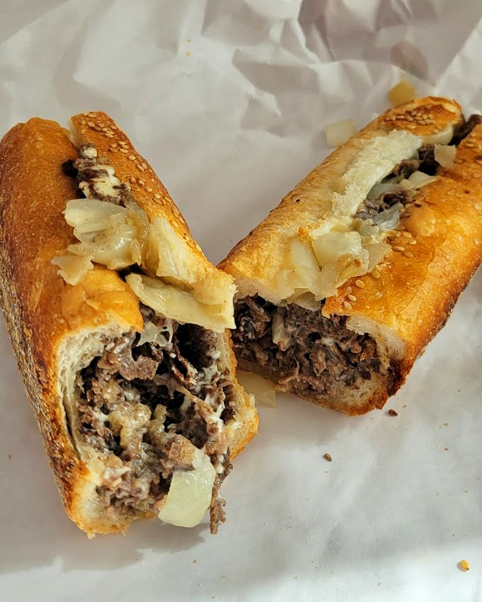 The star of the show: a perfectly chopped cheesesteak on that legendary seeded roll, with cheese melted into every nook and cranny.
