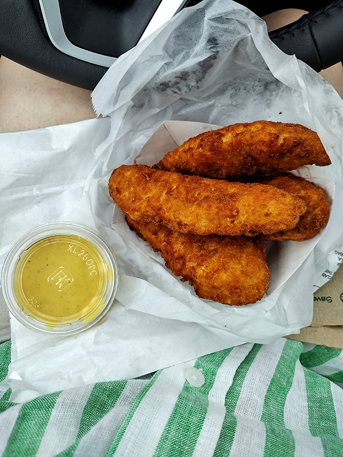 Golden-brown chicken tenders that shatter with each bite, paired with a dipping sauce that could make cardboard taste gourmet.
