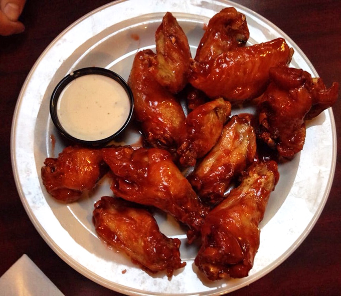 These wings aren't just crispy; they're having a meaningful relationship with that sauce. The kind of wings that make you temporarily forget table manners exist.