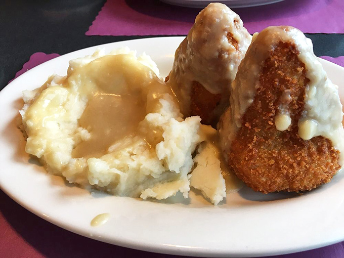 The legendary chicken croquettes—golden-brown on the outside, creamy within—nestled beside a cloud of mashed potatoes bathed in homestyle gravy. Poetry on a plate.