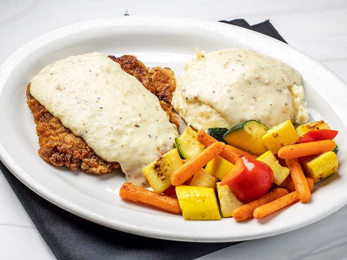 Behold the chicken fried steak in all its gravy-crowned glory, flanked by vegetables pretending to be the healthy option.