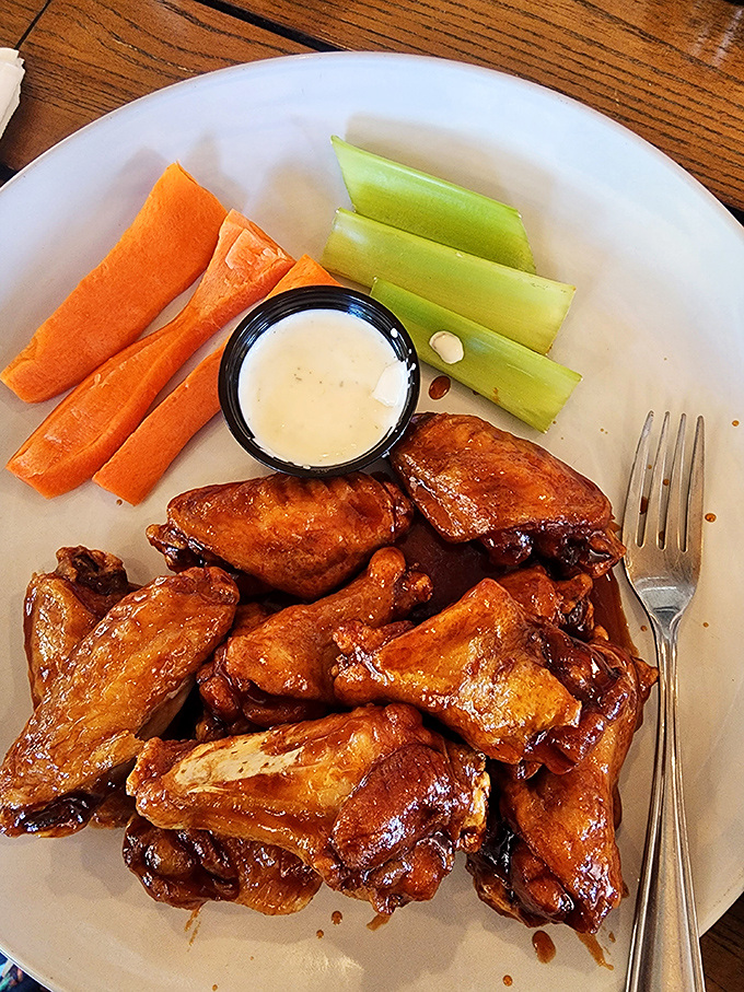 These aren't just wings; they're crispy, saucy masterpieces served with the obligatory celery sticks that nobody actually eats.