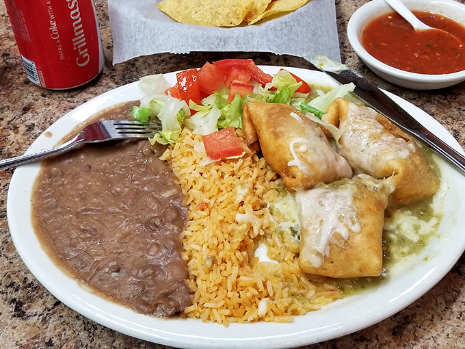 The famous chimichanga lunch special in all its glory – crispy exterior, savory filling, and that perfect trio of rice, beans, and fresh garnish.