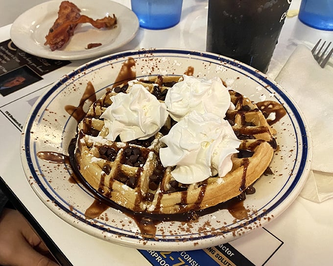 This chocolate waffle isn't just breakfast &ndash; it's dessert with an alibi. Whipped cream mountains melt into chocolate rivers, creating morning magic worth setting an alarm for.